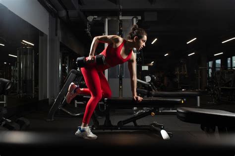 Premium Photo Young Sports Girl In Red Sportswear Lifts Heavy