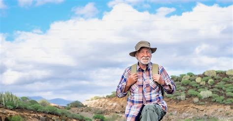 배낭을 메고 산을 바라보며 웃고 있는 수염 난 노인의 초상화 모험의 자유와 건강한 휴가를 즐기는 하이킹 여행에 맞는 노인 사진 Unsplash의 스페인 이미지