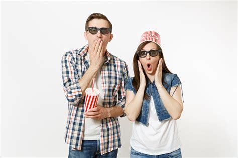 젊은 커플 여자와 남자 날짜에 영화 영화를 보고 머리에 팝콘 양동이와 3d 안경에서 탄산 음료 또는 주스 흰색 배경에 고립의 플라스틱 컵을 들고 충격 극장에서의 감정