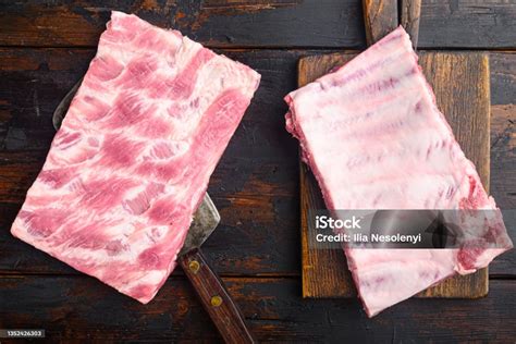 원시 돼지 고기 예비 갈비 나무 도마에 오래된 어두운 나무 테이블 배경에 상단 보기 플랫 누워 스페어 립에 대한 스톡 사진 및