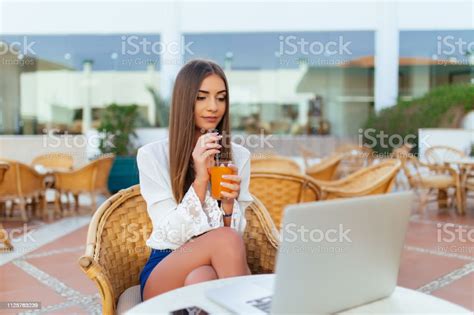 신선한 오렌지 주스 야외 테라스 카페에서 여가 시간을 즐기는 행복 한 멋진 여자 사용 노트북 음료의 여름 휴가 동안 리조트