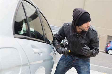 Premium Photo Thief Breaking Into Car With Screwdriver