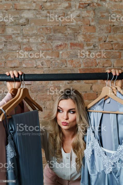 Young Beautiful Woman And Clothing Rack With Different Outfits Stock