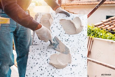 Mason Applies Glue To A Thermal Cladding On A Construction Stock