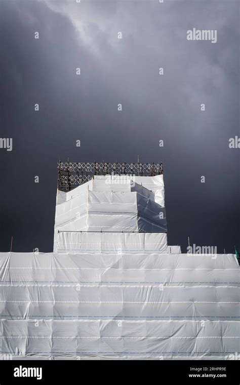 Building Covered In Scaffolding Sheets Against Moody Sky London