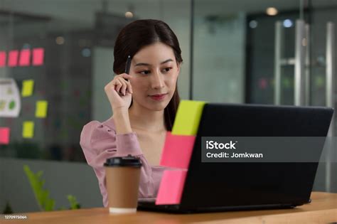 노트북을 생각하고 사무실에서 손에 펜을 들고 일하는 젊은 비즈니스 여성의 초상화스타트업 중소기업 개념 20 24세에 대한 스톡 사진 및 기타 이미지 Istock