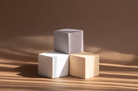 포장 화장품의 프리젠 테이션을위한 3d 연단 다른 색상의 세 큐브 베이지색 흰색 갈색 햇빛의 광선에 받침대의 형태로 배열 입체