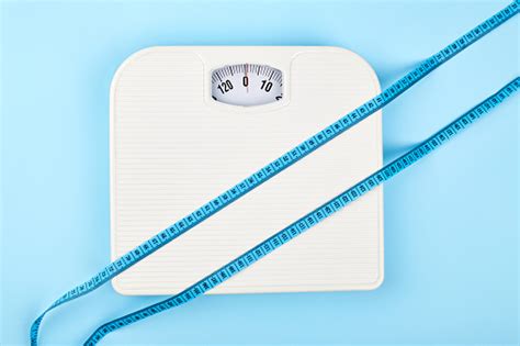 욕실 저울과 파란색 배경에 체중 감량 개념을 위한 측정 테이프 체중 감량을위한 스포츠와 다이어트 욕실 저울 측정 테이프 및 덤벨
