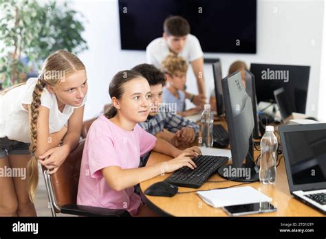 Computer Lesson In Classroom Classmates Solve Problems On Computer
