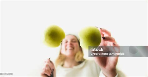 하얀 드레스를 입은 금발 여성의 유리를 통해 낮은 각도에서 녹색 사과를 커팅 보드에서 반으로 자르는 장면 건강한 식습관의 개념 영양 프로그램 및식이 요법 유기농 식품 스톡