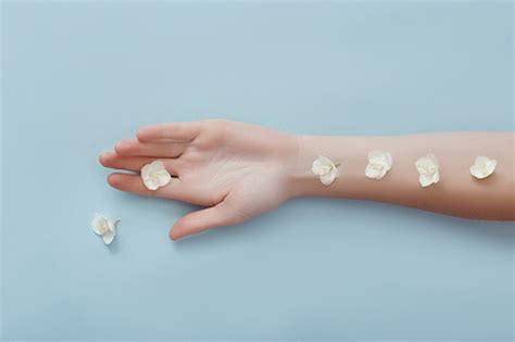 흰색 사과 꽃을 가진 여자의 아름다움 손테이블 파란색 종이 배경에 놓여있다 천연 화장품 핸드 케어 보습 주름 감소 스킨케어 건강