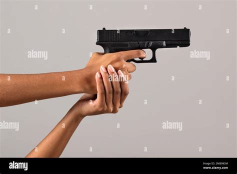 Crop Anonymous African American Woman With Black Gun Pulling Trigger On