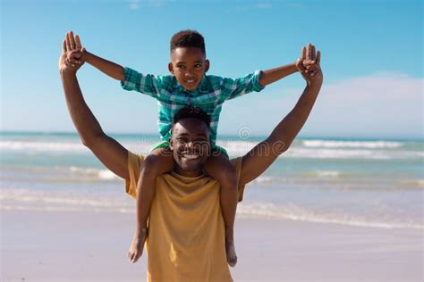 Rear View Of African American Shirtless Young Man Holding Son S Hands