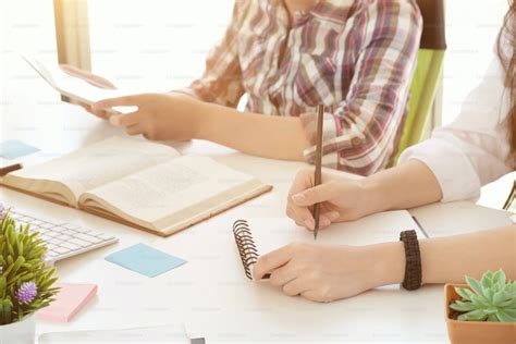 출판사 직장의 자른 샷은 사무실 테이블에서 메모장 종이와 책을 가지고 일하는 사람들입니다 사진 Unsplash의 사진술 이미지