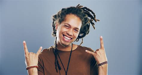 공간 험상궂은 머리 또는 회색 배경에 표현을 위해 스튜디오에서 바위 손 제스처를 가진 남자의 초상화 자메이카 엣지 있는 로커와 악마의 뿔 기호 펑키한 이모티콘 멋진 펑크