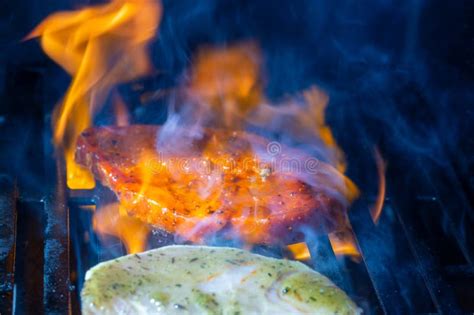 Marinated Pork Steak And Chicken Steak On The Grill Grate With Flames