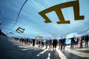 Фото Люди держат национальный флаг крымских татар - УНИАН