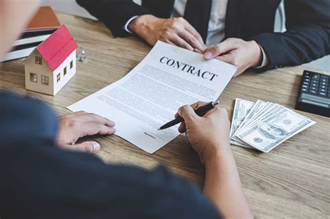 부동산 중개인은 승인 된 모기지 신청서 구매 또는 주택 보험에 대한 모기지 대출 제안에 관한 고객 서명 계약 부동산에 계약 양식에 도달 거래자에 대한 스톡 사진 및 기타