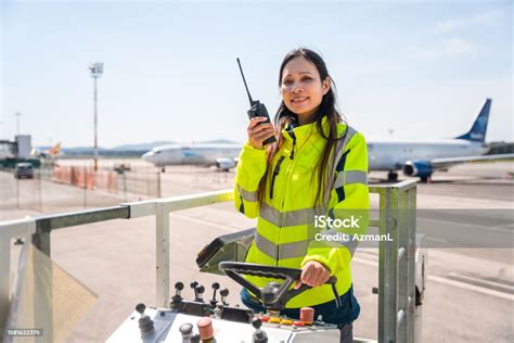 asian female airport worker operating a container transporter stock