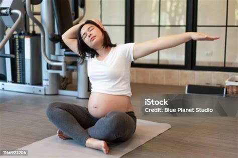 요가룸의 피트니스 센터에서 활동적인 임산부 운동을 합니다 임신 한 배에 아기를 들고 젊은 기대 어머니 출산 전 관리 및 여성 임신 개념 건강한 생활방식에 대한 스톡 사진 및