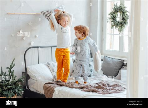 Bruder Und Schwester Im Schlafanzug Spielen Mit Kissen Auf Dem Bett C Stockfotografie Alamy