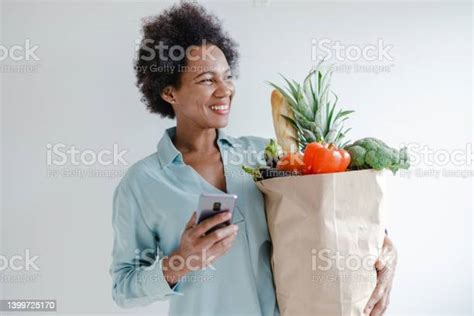 흰색 벽 앞에서 식료품으로 가득 찬 종이 봉투를 들고있는 여성의 초상화 슈퍼마켓에 대한 스톡 사진 및 기타 이미지 슈퍼마켓
