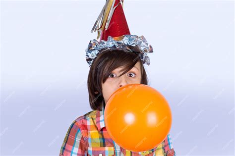 Niño Pequeño Inflando Un Globo Foto Premium