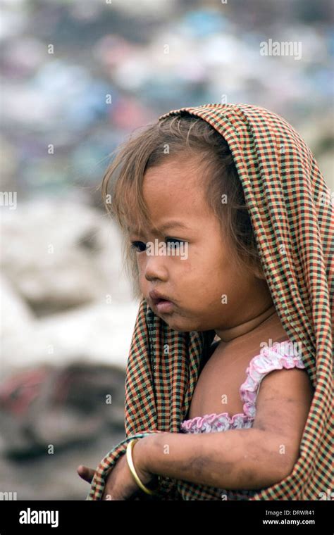 A Young Girl Living In Poverty Is Standing Amidst Trash At The Toxic