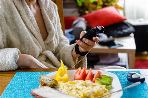 현대 당뇨병 치료 여자는 포도당 수준을 확인하고 그녀의 건강한 아침 식사 전에 인슐린 펌프와 인슐린을 투약 당뇨병에 대한 스톡