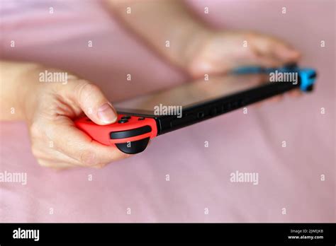 Woman Playing Game On Handheld Console Lying On A Bed Selective Focus