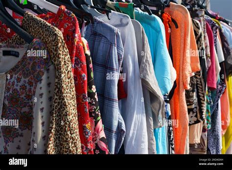Womens Summer Clothes Of Different Colors Are Hung On Hangers In A Row