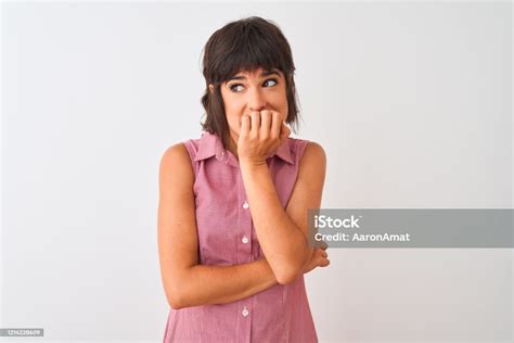 빨간 여름 셔츠를 입고 있는 젊은 아름다운 여성은 손톱을 물고 입에 손을 대고 긴장하고 스트레스를 받고 고립된 흰색 배경 위에 서 있습니다 불안 문제 감정에 대한 스톡 사진