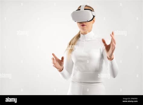 Focused Woman In White Clothes Wearing Vr Glasses Equipment For Virtual