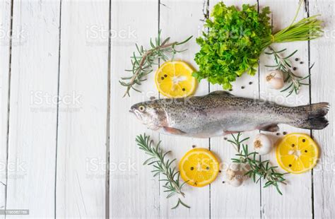 파슬리 마늘 로즈마리와 오래된 흰색 테이블에 신선한 송어 맛있는 생선은 먹을 준비를 합니다 상단 각도 보기 건강한 생활방식에