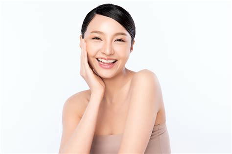 뷰티 페이스 건강한 피부 초상화를 만지는 미소 짓는 아시아 여성 화이트 배경에 신선한 빛나는 수화 얼굴 피부와 자연 메이크업과