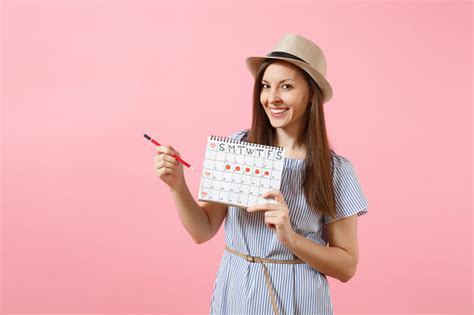 파란 드레스 모자 들고 빨간 연필 분홍색 배경에 고립 된 생리 일을 확인 하기 위한 여성 기간 달력에서 젊은 여자의 초상화 의료