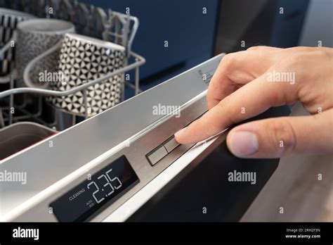 Man Pushing Start Button On The Control Panel Of The Dishwasher Stock Photo Alamy