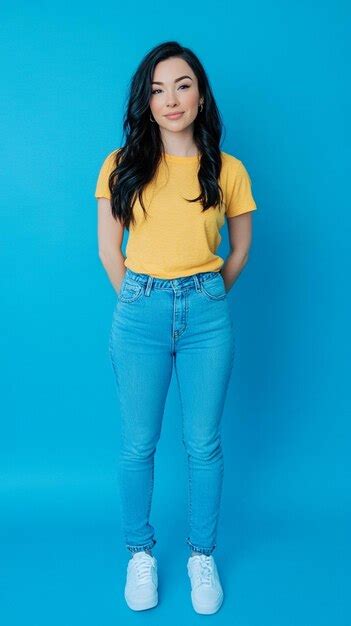 A Woman In A Yellow Shirt Stands In Front Of A Blue Background