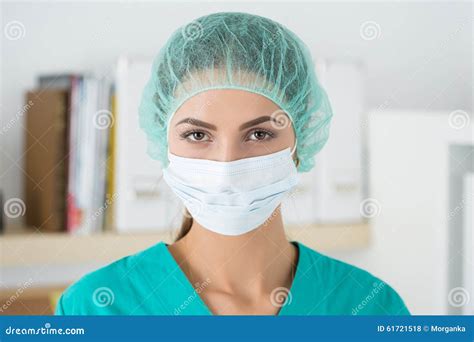 Portrait Of Female Surgeon Wearing Protective Mask And Cup Stock Photo