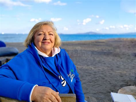 Portrait Of A Mature Woman Enjoying Time On The Beach Looking At The