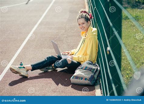 Feliz Estudiante Sentada En El Suelo Y Sonriendo Mientras Sostiene Su