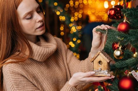 Premium Photo Upset Redhead Young Woman Decorating Christmas Tree Alone At Living Room With