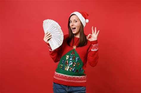 산타 소녀 확인 제스처를 보여주는 달러 지폐 현금 돈 빨간 배경에 고립의 많은 무리를 들고 흥분 행복 한 새 해 2019 축 하 휴일 파티 개념입니다 복사 공간을 비웃는 다