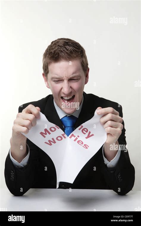 Man In A Suit Sat At A Desk Ripping A Piece Of Paper Up With The Words