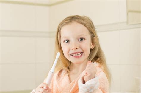 Una Niña Feliz Y Sonriente Se Cepilla Los Dientes Con Un Cepillo De