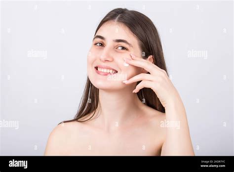 Beautiful Woman Smiling To Camera As Using Softening Face Cream Isolated On White Background