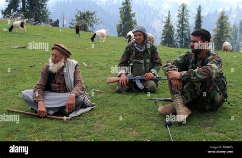 Two Afghan National Army Soldiers Talk With A Local Afghan July 19