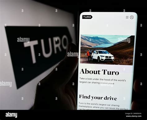person holding cellphone with webpage of us peer to peer carsharing