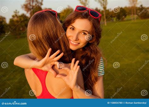 Twee Jonge Mooie Meisjes Houden Elkaar Vast En Tonen Hart Stock Foto