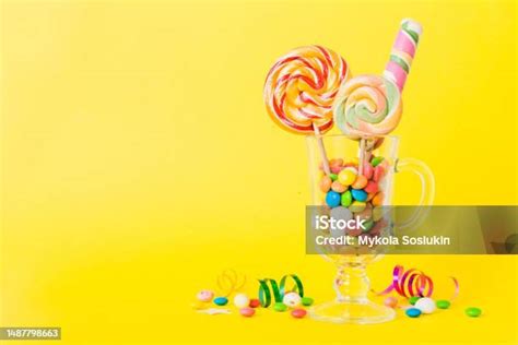 밝은 배경 배경에 테이블에 컵에 화려한 사탕 큰 소용돌이 막대 사탕 사탕 가게에서 맛있는 과자로 가득 찬 항아리의 창조적 인